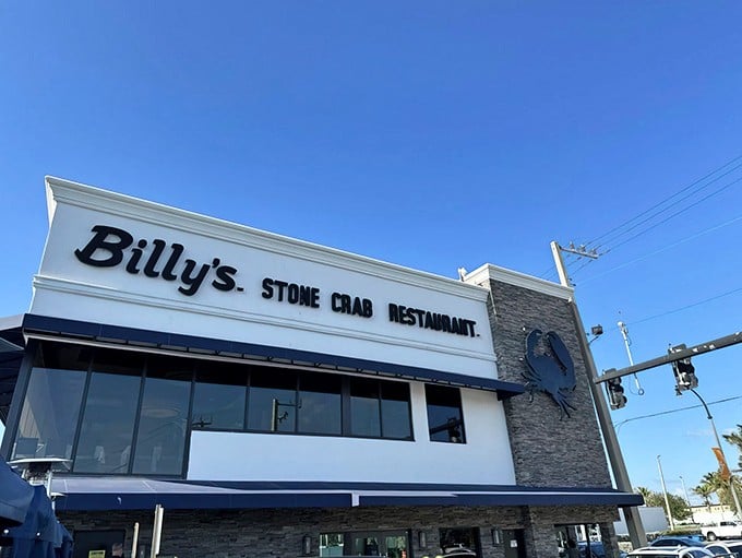 The iconic blue crab emblem welcomes seafood pilgrims to Billy's Stone Crab, standing proud against the Florida sky like a beacon of deliciousness.