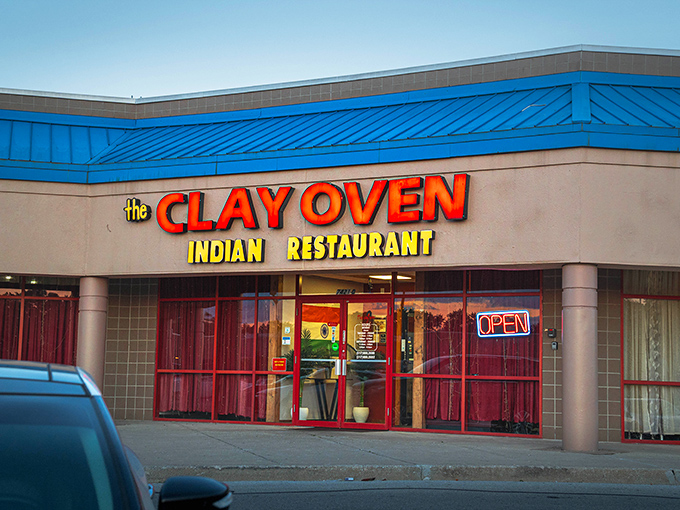 The bright blue roof and bold signage of Clay Oven stand out like a beacon of culinary promise in an unassuming strip mall.