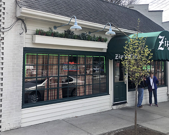 The charming exterior of Zip's Cafe welcomes you with colorful flower boxes and that iconic green awning—a Cincinnati landmark that promises comfort without pretension.