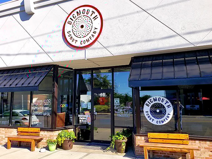 The unassuming storefront of Bigmouth Donut Company beckons with its clean lines and rustic wooden benches—a temple of fried dough hiding in plain sight.