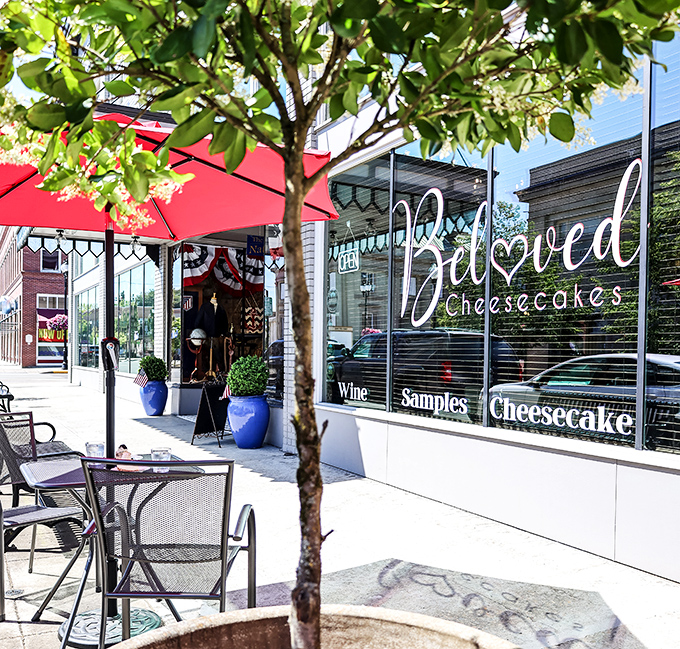 The storefront beckons with red umbrellas and promises of "Samples, Cheesecake, Coffee" – three magic words that could solve most of life's problems.