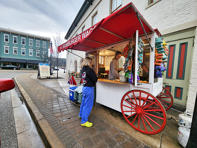The iconic Hamburger Wagon stands proudly on Miamisburg's brick sidewalks, its red wheels and awning a beacon of burger hope for hungry passersby.