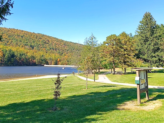 Mother Nature's masterpiece on full display – autumn mountains embracing a serene lake while picnic tables patiently wait for your sandwich collection.