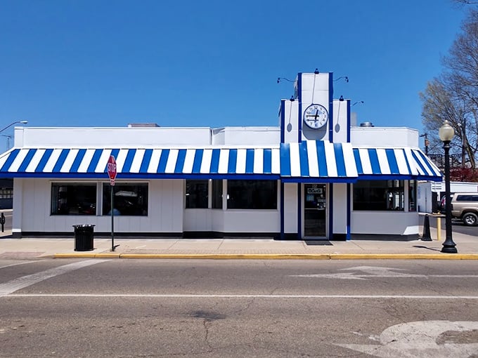 That iconic blue and white awning isn't just eye-catching—it's a time machine disguised as a diner, beckoning hungry travelers with promises of comfort food perfection.