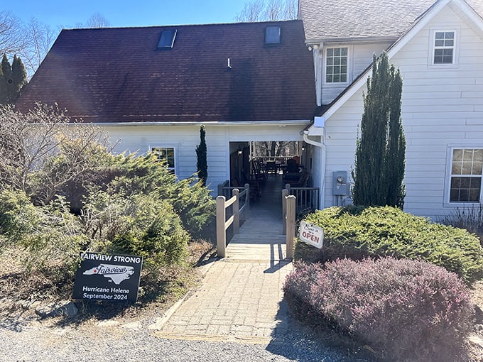 A charming white farmhouse beckons with its stone pathway and "OPEN" sign – like a storybook cottage that happens to make incredible sandwiches.