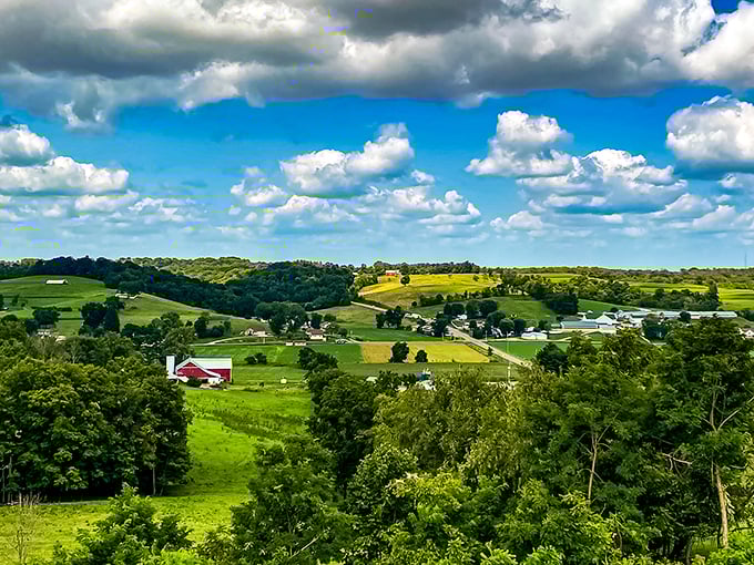 Classic Americana unfolds before your eyes – horse-drawn plows still working fertile fields while that iconic red barn stands sentinel over generations of tradition.