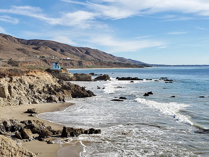 The California coastline stretches out like nature's own infinity pool. This panoramic view of Leo Carrillo State Park captures the meeting of rugged hills and sparkling Pacific waters.