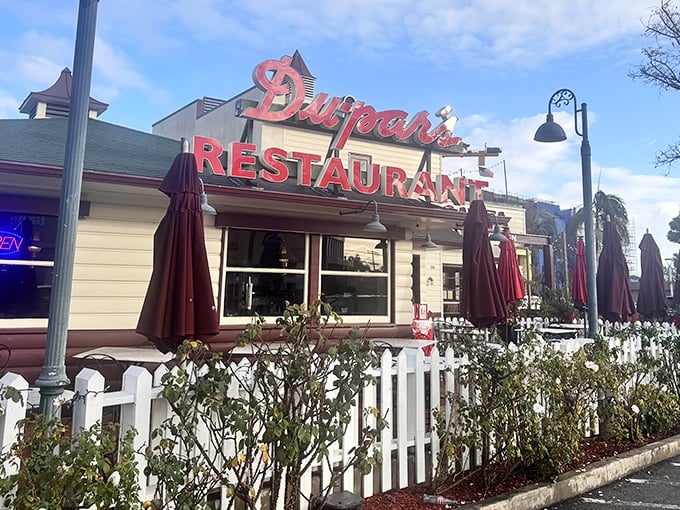 That iconic red neon sign isn't just announcing a restaurant—it's signaling your imminent reunion with pancake perfection at the edge of LA's historic Farmers Market.