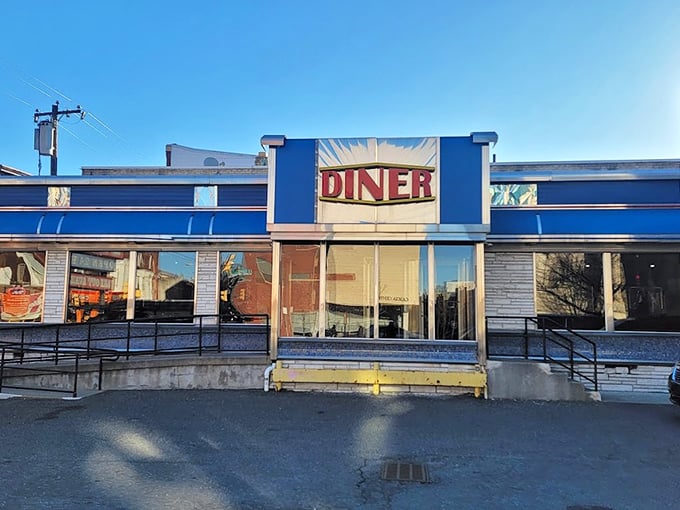 The classic blue and silver exterior of Broad Street Diner gleams like a beacon of breakfast hope on Philadelphia's urban landscape.