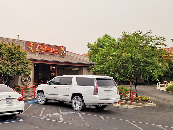 The Western welcome begins at the door. Cattlemens' rustic exterior promises what every carnivore dreams of—a serious steak experience awaiting inside.