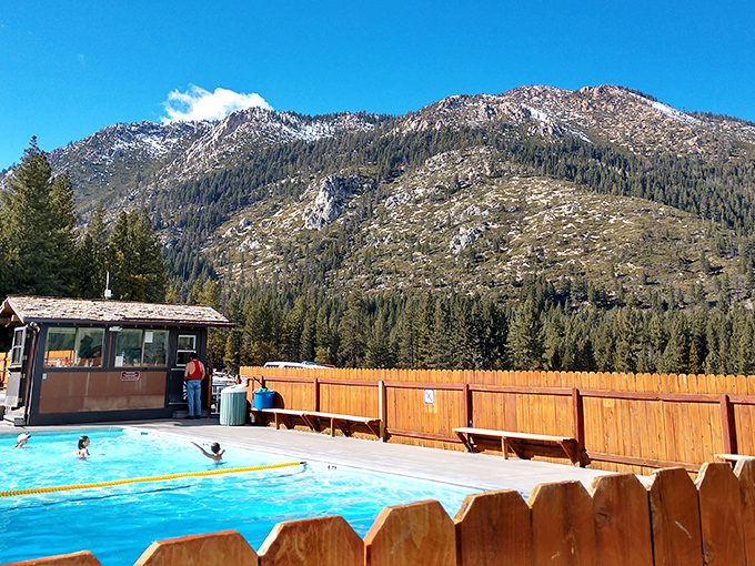Nature's own infinity pool setup. The rustic hot springs complex sits perfectly framed by towering Sierra pines and dramatic mountain backdrops.