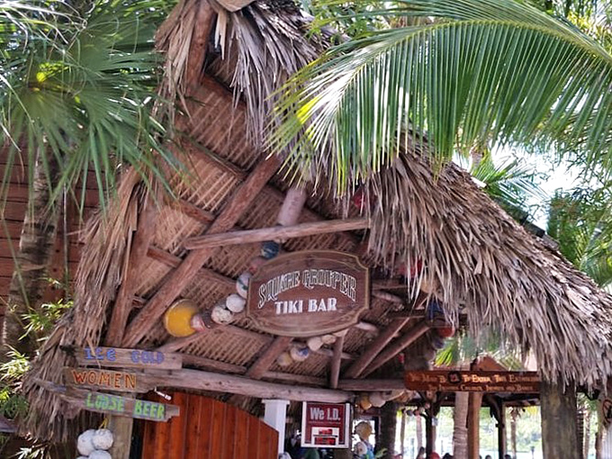 The entrance says it all – palm fronds, weathered wood, and that iconic sign promising the kind of Florida experience you can't manufacture in a boardroom.