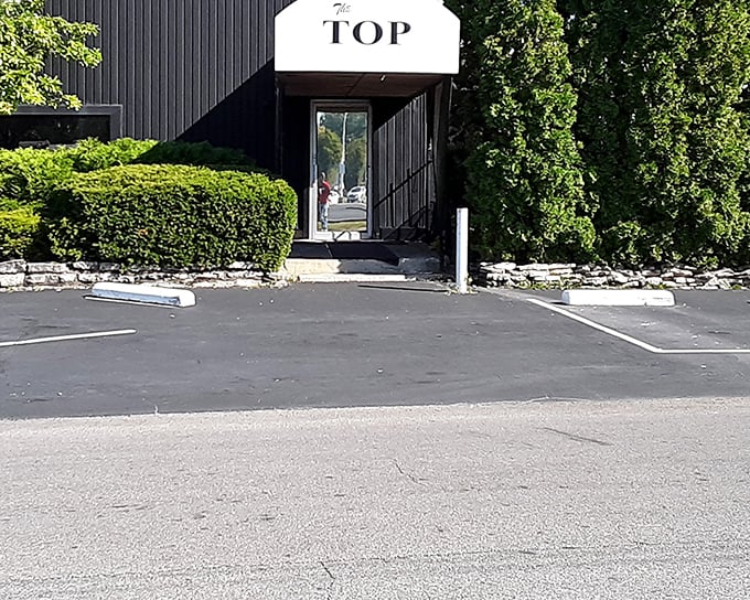 The geometric, mid-century modern entrance to The Top Steakhouse stands like a portal to another era—one where dinner was an event, not just a meal.
