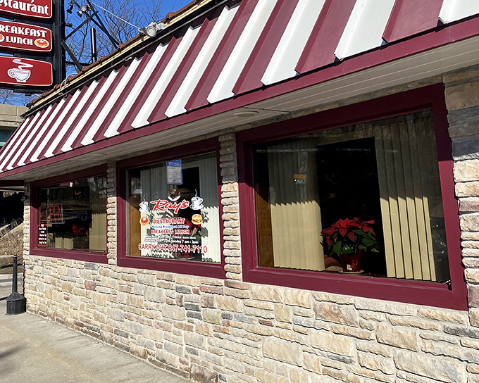 The red and white awning of Ray's Diner beckons like a lighthouse for hungry souls navigating the streets of Elgin. Classic stone exterior promises timeless comfort within.