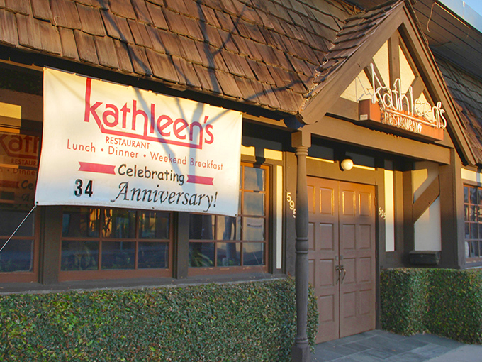 The charming cottage-like exterior of Kathleen's Restaurant beckons with its stone facade and distinctive blue doors—like a storybook breakfast haven come to life.