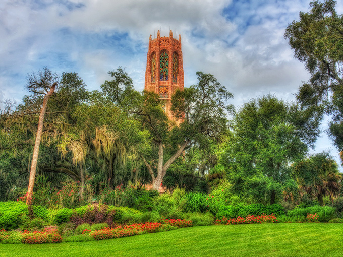 Nature's cathedral awaits as Bok Tower rises majestically above the lush Florida landscape, a pink marble sentinel guarding paradise.