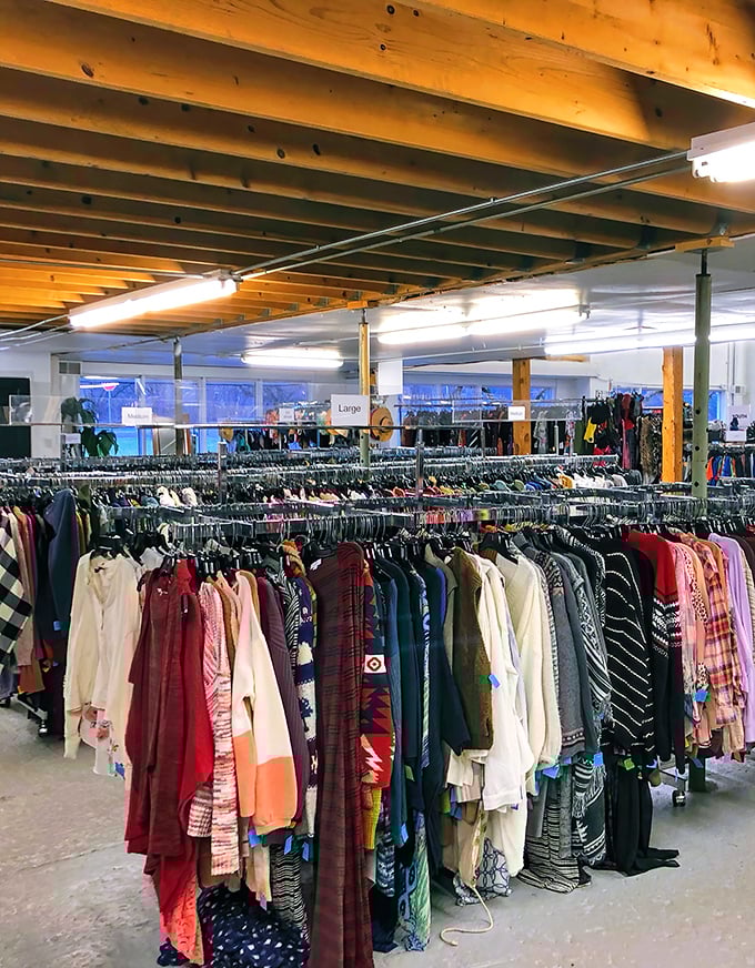Treasure hunting paradise! Endless racks of clothing stretch beneath rustic wooden beams, each hanger potentially holding your next favorite outfit.