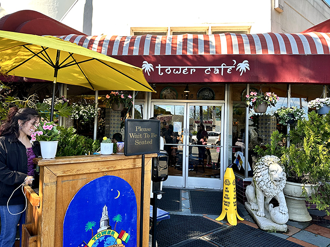 Welcome to flavor paradise! Tower Café's vibrant exterior with its distinctive red awning and lush greenery promises an escape from ordinary breakfast experiences.