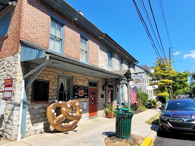 The historic stone and brick facade of Julius Sturgis Pretzel Bakery stands as a testament to American ingenuity, complete with an oversized pretzel sculpture that practically beckons you inside.