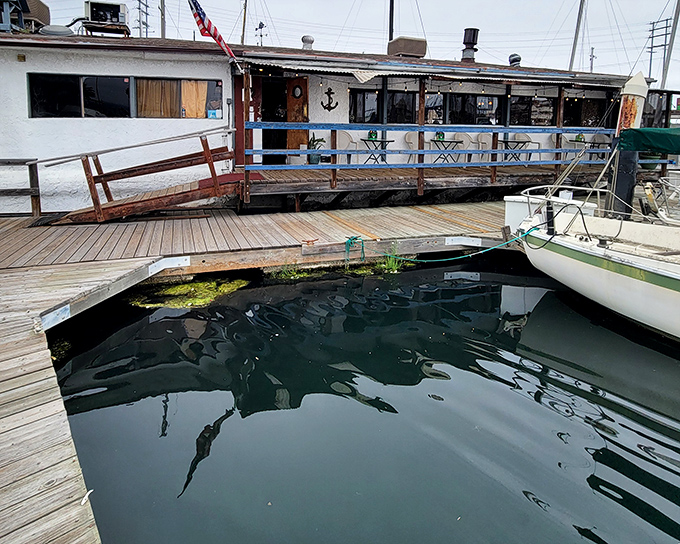 The floating charm of Chowder Barge welcomes seafood lovers with weathered wooden planks and American flag—nautical dining that actually bobs with the tide.