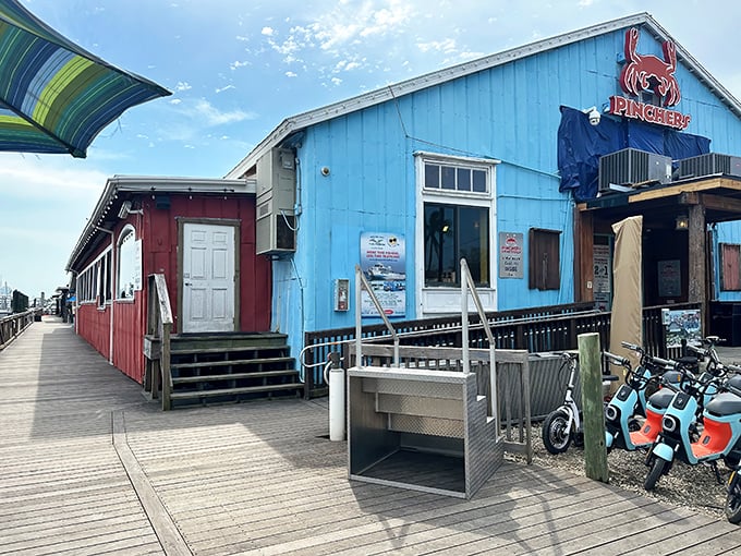The bright blue exterior of Pinchers stands like a cheerful beacon on the Naples waterfront, promising seafood treasures within those colorful walls.