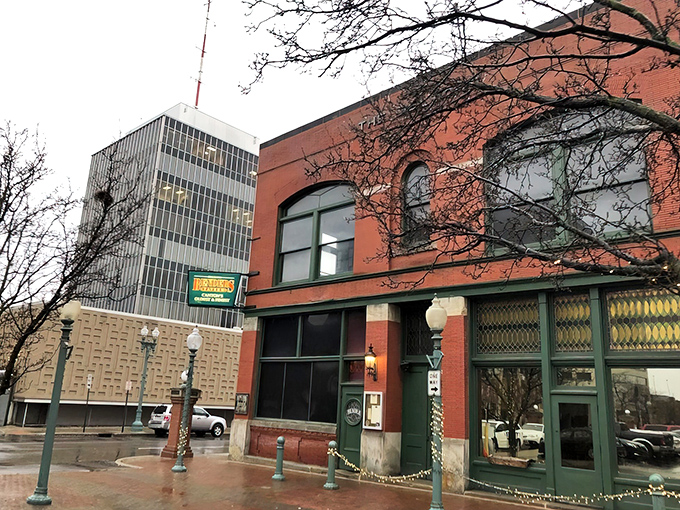 The historic brick façade of Bender's Tavern stands proudly in downtown Canton, where American flags flutter like culinary battle standards over the inviting outdoor seating area.