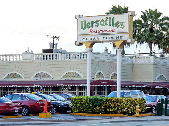 The iconic green-lettered sign of Versailles Restaurant stands proudly above its white façade, a beacon of Cuban culinary tradition in Miami's Little Havana.