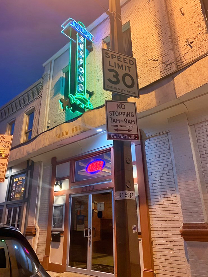 The iconic neon green crab sign beckons seafood lovers like a maritime lighthouse on Baltimore's urban shore.
