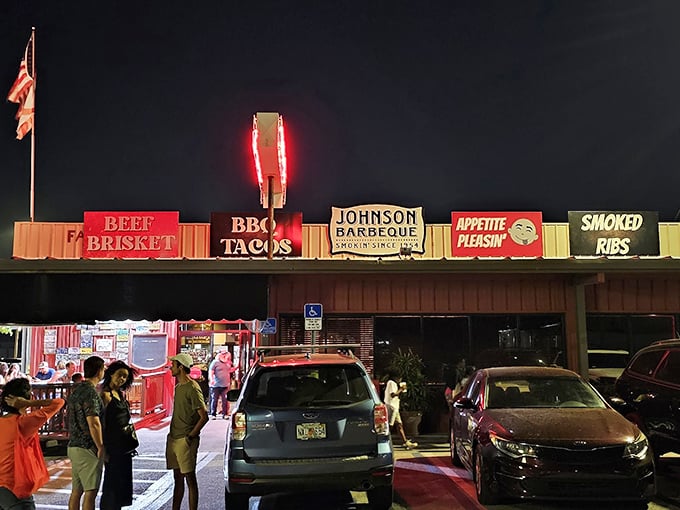 The neon glow of Johnson Barbeque's signage cuts through the night like a beacon for hungry souls. BBQ tacos, beef brisket, and smoked ribs—the signs tell you everything you need to know.
