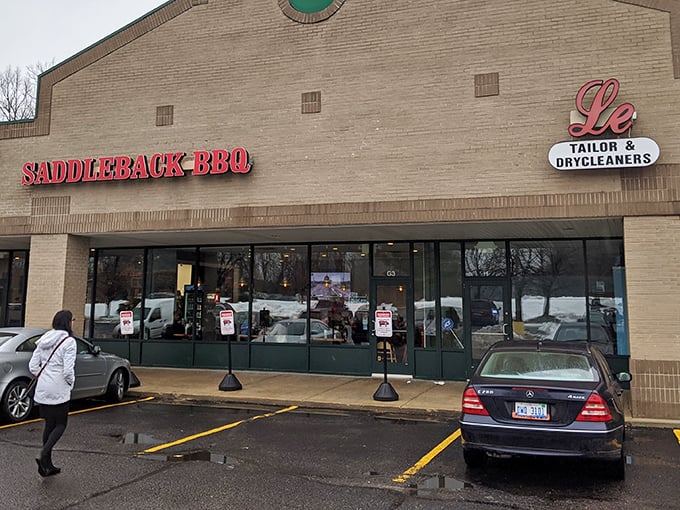 The unassuming storefront hides barbecue greatness like a superhero's secret identity. Red letters promise smoky delights within.