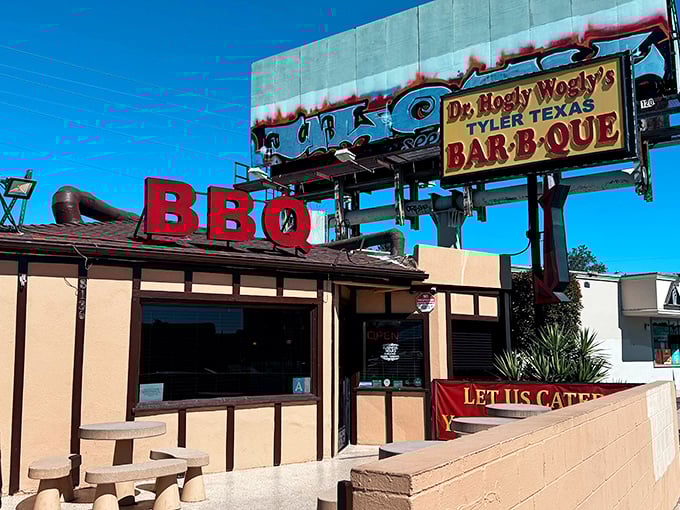 That iconic sign beckons like a smoky siren call to BBQ lovers. The red letters spell out what your nose already knows.