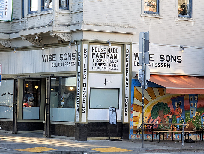 The unassuming storefront of Wise Sons on 24th Street hides culinary treasures that would make your bubbe weep with joy. Classic delicatessen signage promises authenticity within.