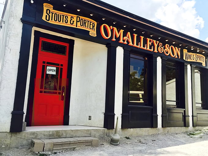 That red door isn't just an entrance—it's a portal to underground beer paradise. O'Malley's classic storefront gives only the slightest hint of what awaits below.