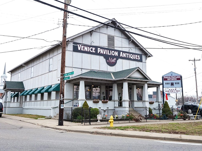The white clapboard exterior of Venice Pavilion Antiques stands like a time capsule on the corner, promising treasures within that HGTV stars would battle over.