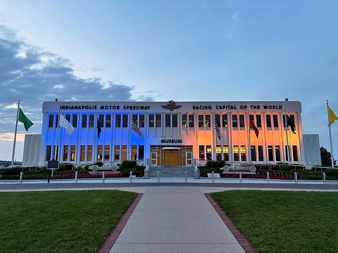 The modernist façade of the Indianapolis Motor Speedway Museum stands proudly as the guardian of racing history, with A.J. Foyt's 1970 winner immortalized in concrete out front.