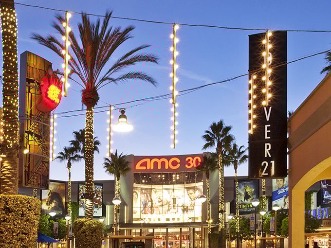 Palm trees frame the AMC 30 like nature's own red carpet, welcoming shoppers to take a cinematic break between bargain hunts.