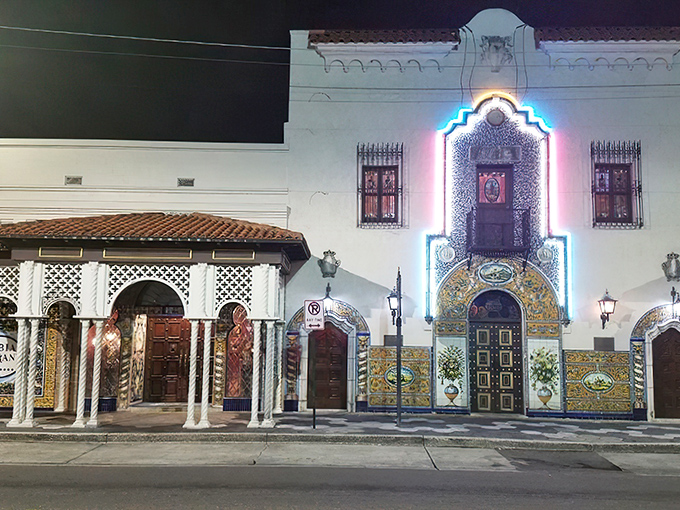The Columbia's façade glows like a Spanish palace at night, its ornate tilework and dramatic lighting beckoning hungry travelers like a culinary lighthouse.