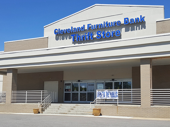 The blue sign beckons like a lighthouse to bargain hunters – Cleveland Furniture Bank Thrift Store, where wallet-friendly treasures await.