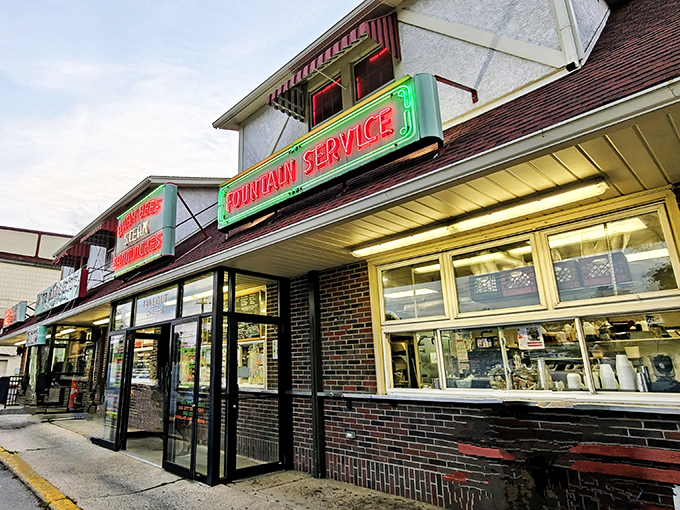 The vintage neon sign beckons like an old friend, promising comfort food treasures behind that unassuming brick facade. Culinary time travel starts here.