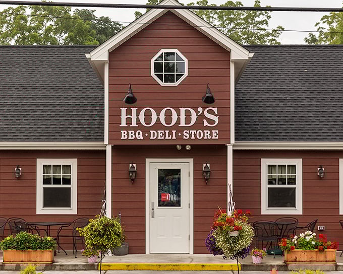 The barn-red exterior of Hood's BBQ welcomes hungry travelers like a beacon of smoky promise. Those hanging flower baskets aren't just for show—they're saying "slow down and eat something wonderful."