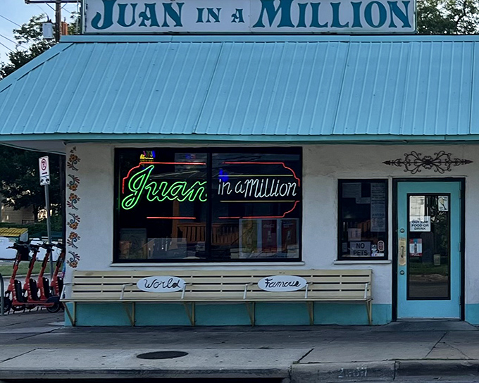 The neon sign beckons like an old friend – "Juan in a Million" glows against the simple white exterior, while the "World Famous" bench outside tells you everything you need to know.