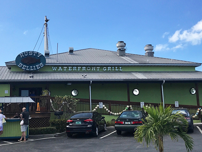 The cheerful yellow exterior of Rusty Bellies promises seafood treasures within, like a maritime version of Willy Wonka's factory—but with stone crabs instead of chocolate.