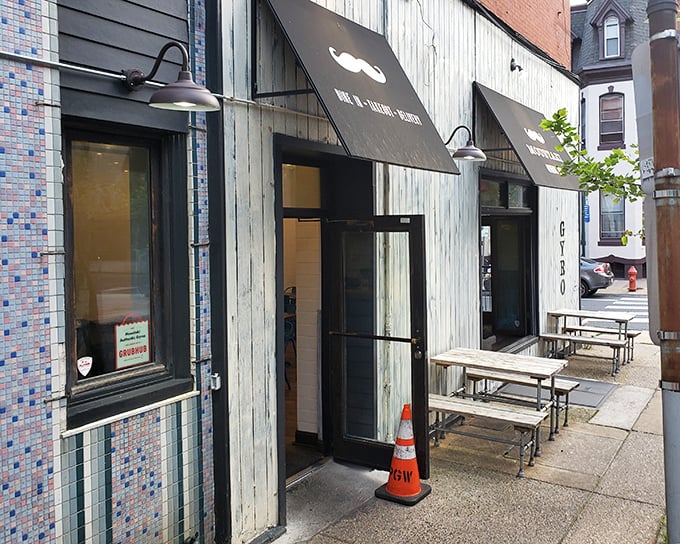 The unassuming storefront with its playful mustache logo promises Greek treasures within. Sometimes the most memorable meals hide behind the simplest facades.