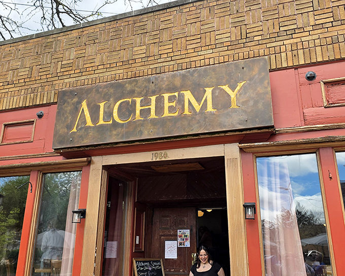 The pink facade and weathered "ALCHEMY" sign aren't trying to impress anyone—they're too busy promising authentic flavors that will do all the talking necessary.