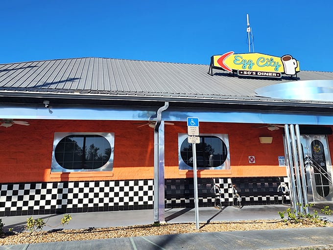 The vibrant orange exterior with classic black-and-white checkerboard trim isn't just eye-catching—it's practically sending breakfast smoke signals to hungry travelers on the highway.