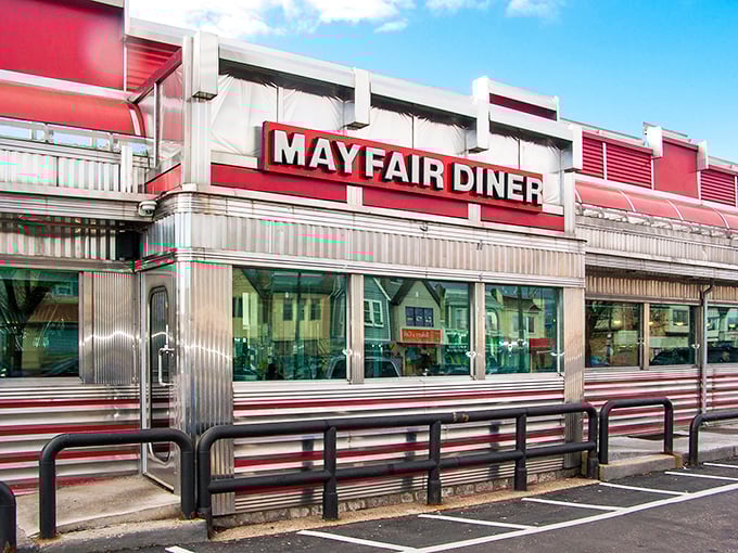 The gleaming stainless steel exterior of Mayfair Diner stands as a shiny time capsule on Frankford Avenue, beckoning hungry Philadelphians with its iconic red signage.