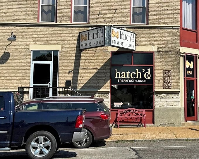 The charming brick exterior of hatch'd STL beckons hungry St. Louis locals with its vintage signage and welcoming red bench—breakfast paradise found!