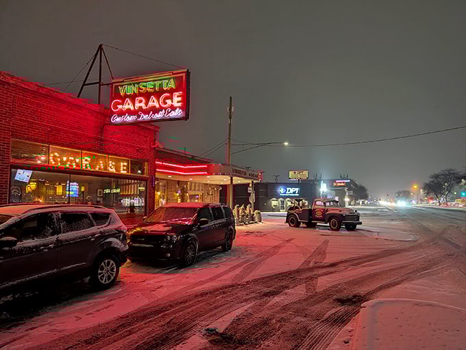 That neon glow against fresh snow isn't just a sign—it's a beacon calling hungry travelers home. Woodward Avenue's automotive shrine transforms into a culinary sanctuary after dark.