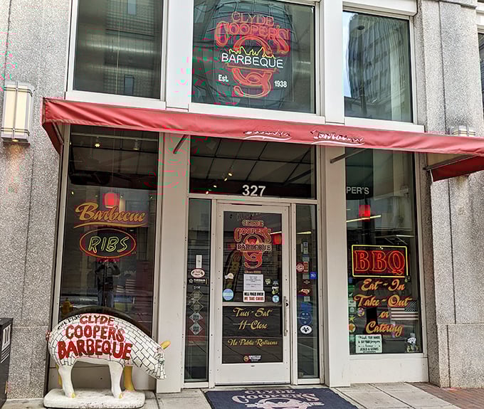 The iconic red awning and pig statue welcome you to Clyde Cooper's – where barbecue dreams come true since 1938.