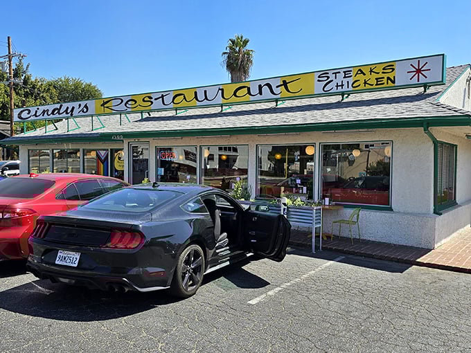 The classic yellow sign beckons like a time machine to simpler days. Cindy's exterior promises comfort food treasures beneath those palm trees.